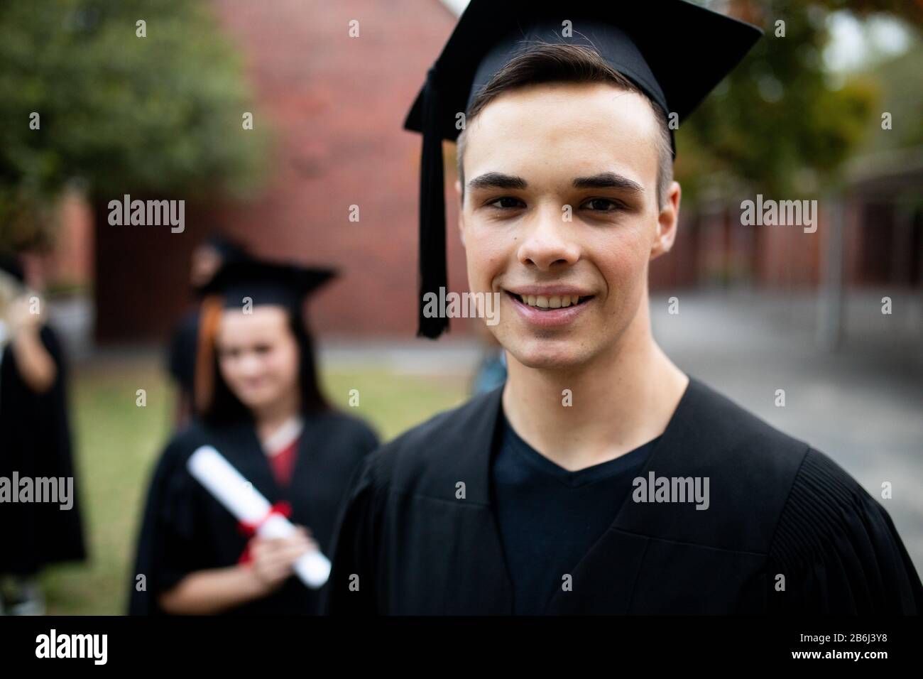 Front view of student graduated looking at the camera Stock Photo - Alamy