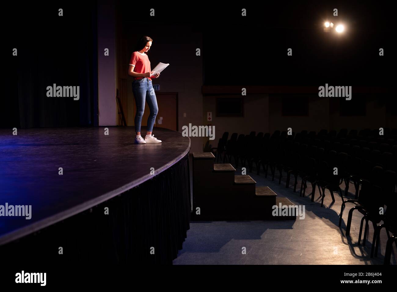 Side view of student reading a text in a theater Stock Photo - Alamy