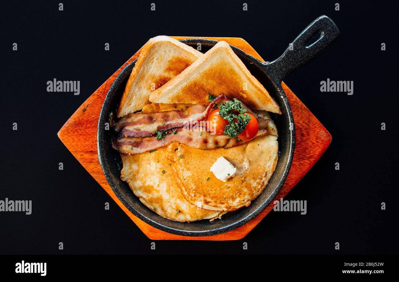 Western brunch menu with pancake, bacon, toast bread, butter, tomatoes ...