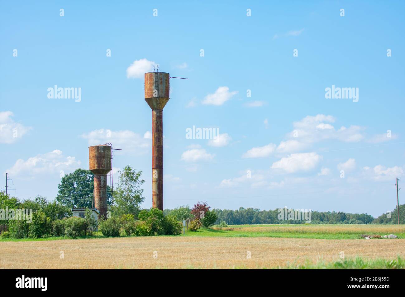 Two old rusty water towers in countryside field blue sky Stock Photo ...