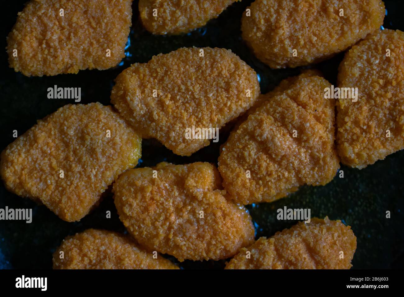 Golden chicken nuggets frying in hot oil black dark pan Stock Photo - Alamy