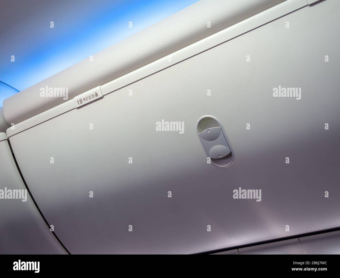 Close-up hand luggage compartment in cabin economy class on the low ...