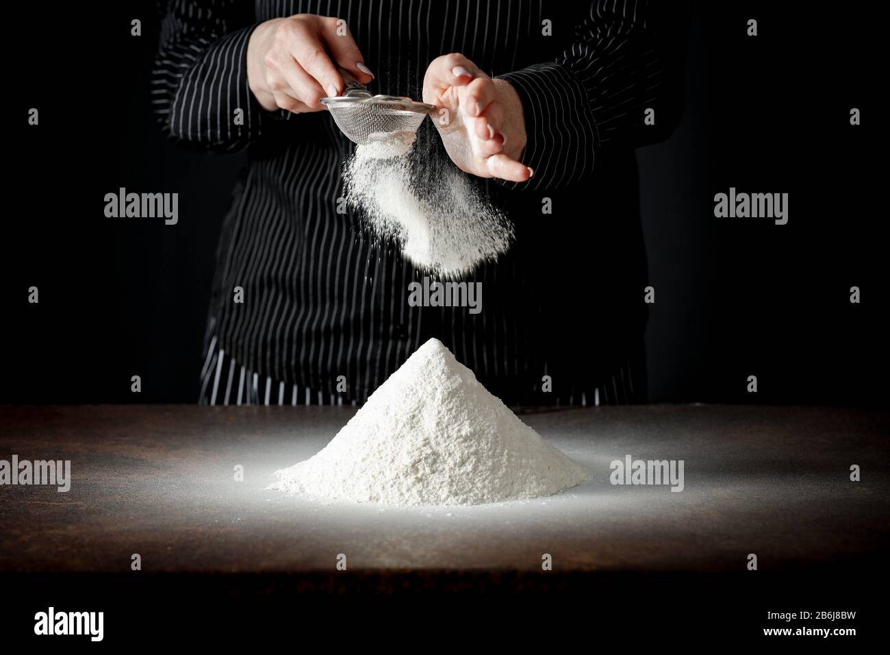 Flour on a kitchen table on a black moody background in the morning ...