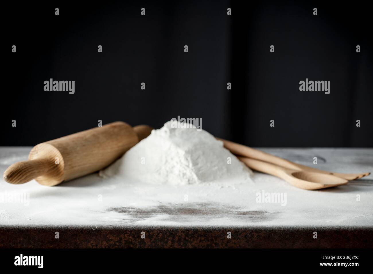 Flour on a kitchen table on a black moody background in the morning ...