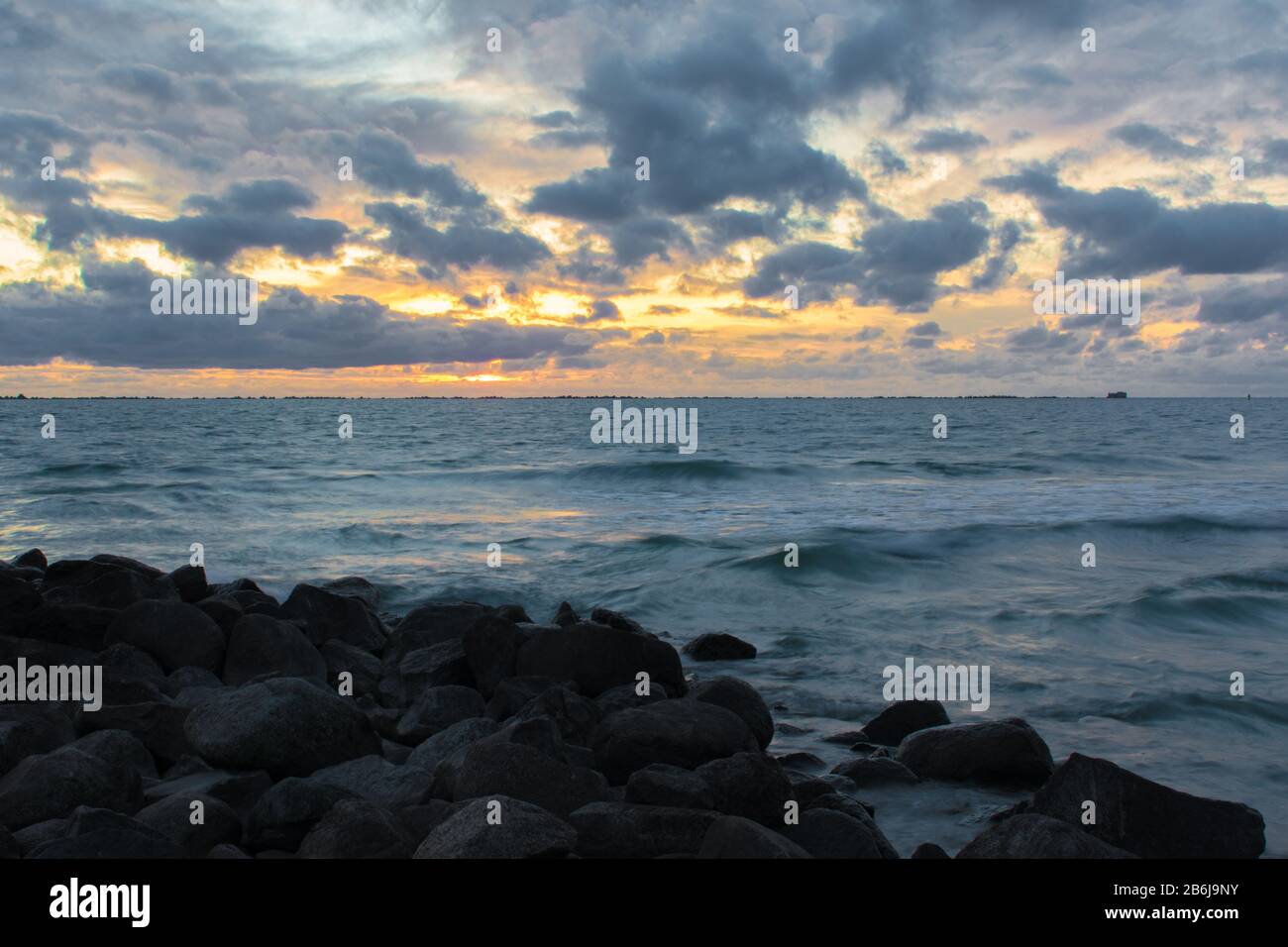 Beautiful orange sunset sky reflection on calm sea Stock Photo - Alamy