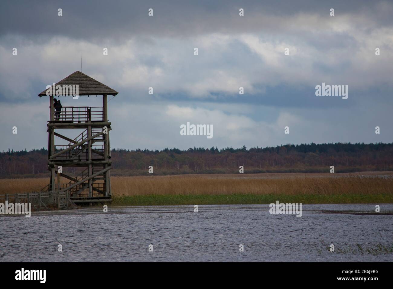 Floating wooden viewing tower on water.Latvia. Cloudy blue sky ...