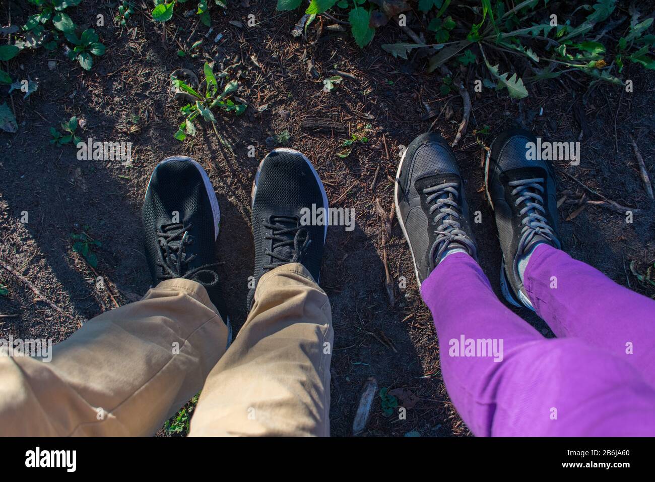 A view from above on the legs of a man and a woman standing next to ...