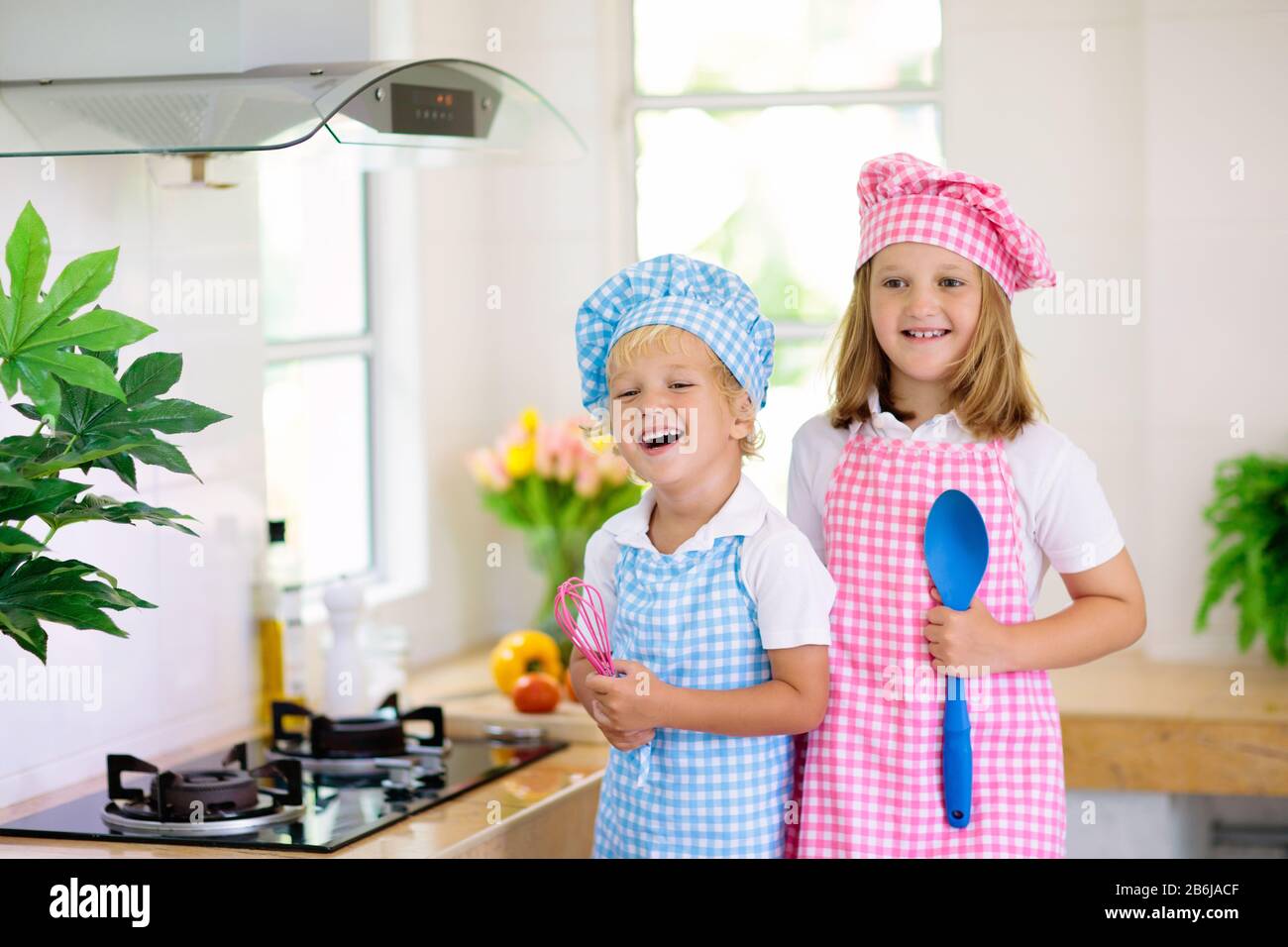 Kids cook in white kitchen. Children cooking at home. Little boy and ...