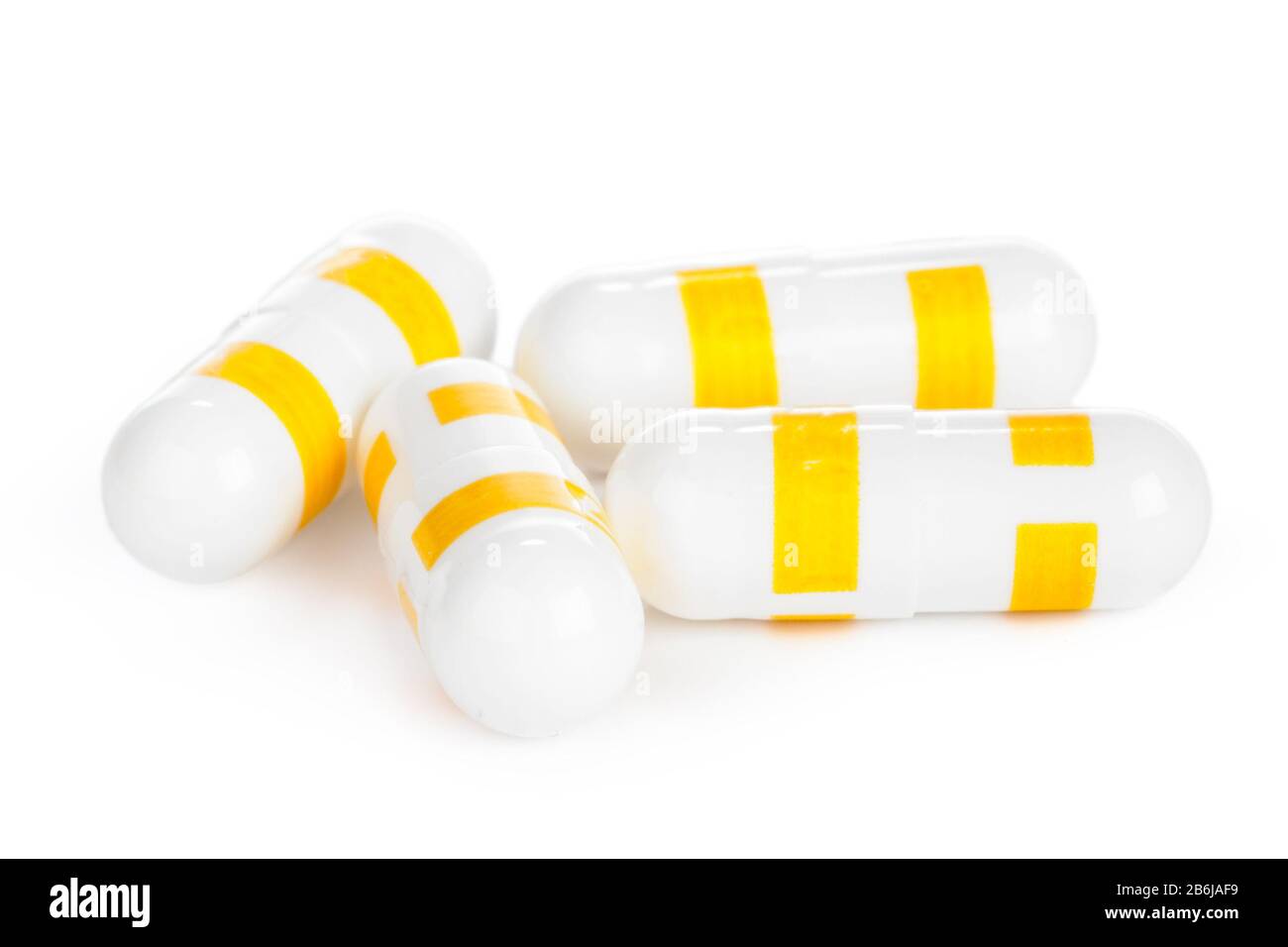 yellow vitamin pills isolated on white background Stock Photo - Alamy
