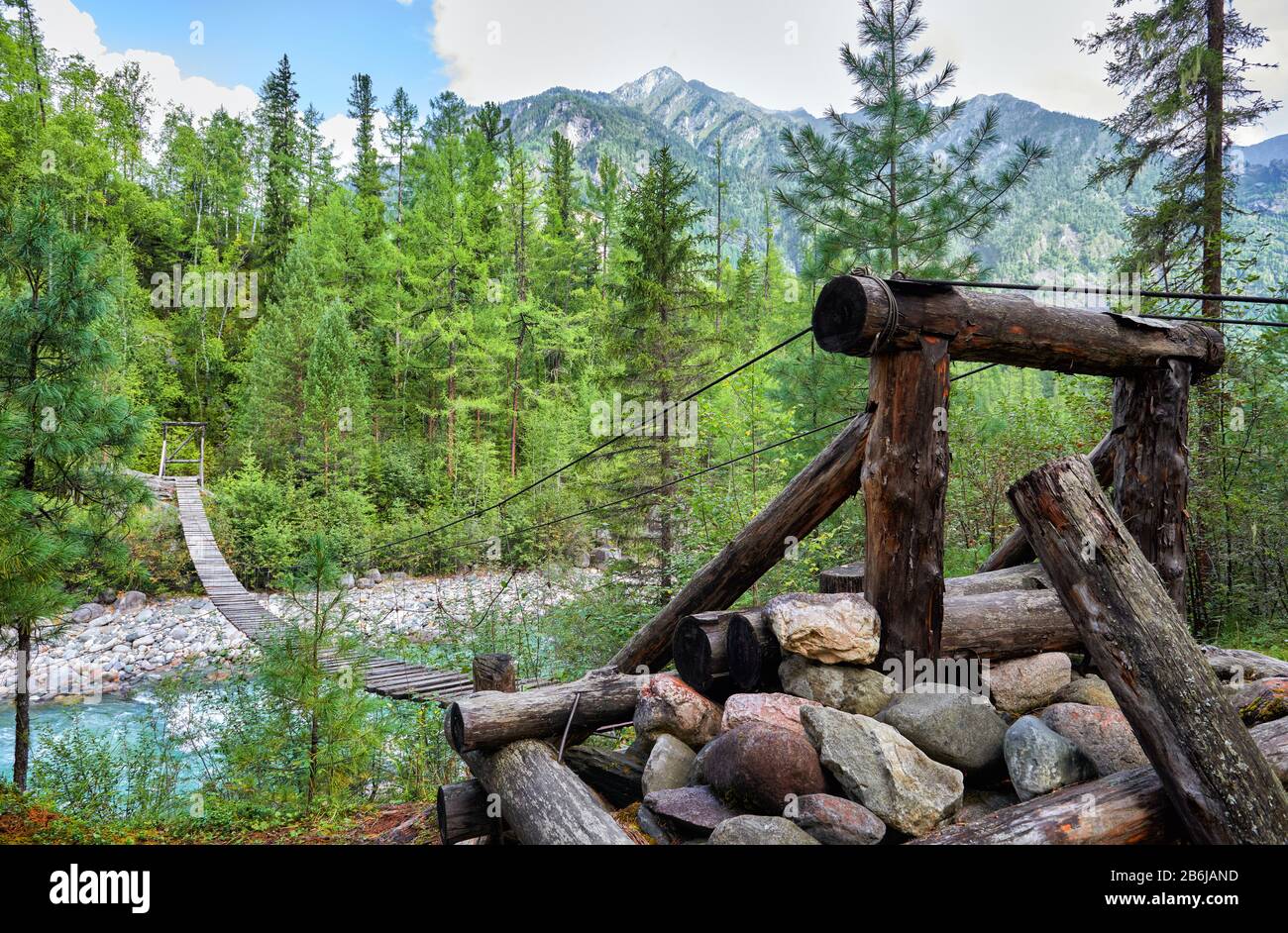 Log support of suspension bridge in forest. The design is made of ...