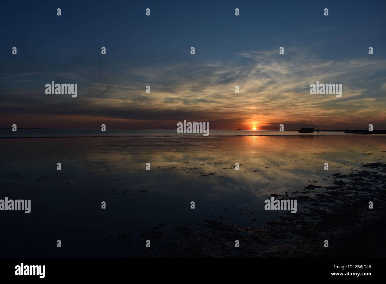 Beautiful orange sunset sky reflection on calm sea Stock Photo - Alamy