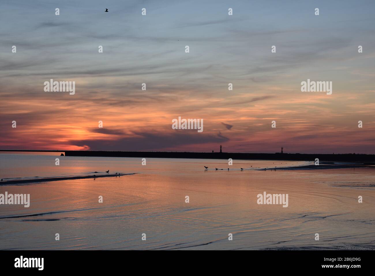 Beautiful orange sunset sky reflection on calm sea Stock Photo - Alamy