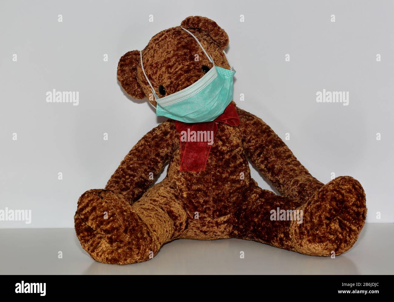 brown teddy bear with red ribbon on neck and medical face / facial ...