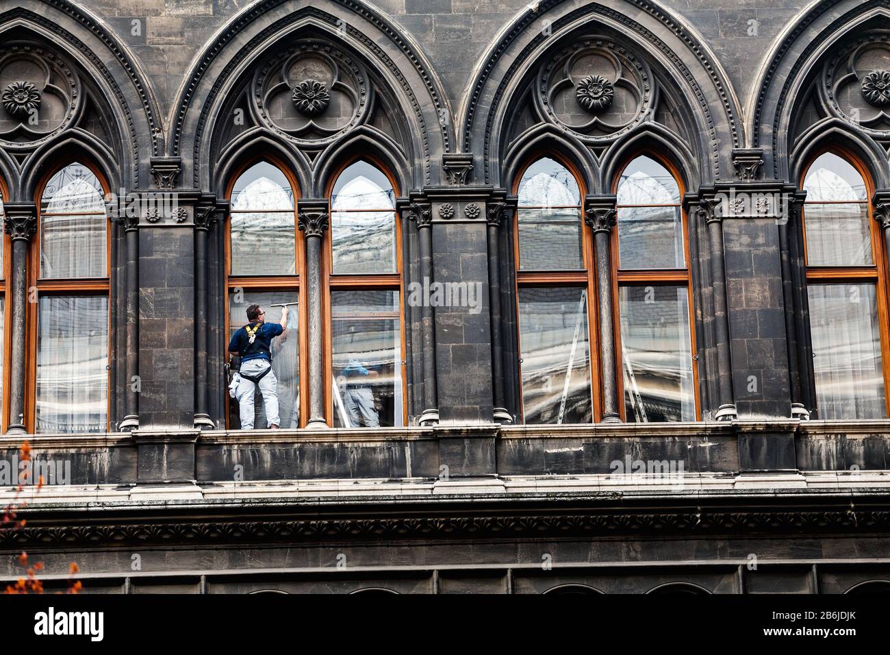 Cleaning service worker washing old gothic building window facade Stock ...