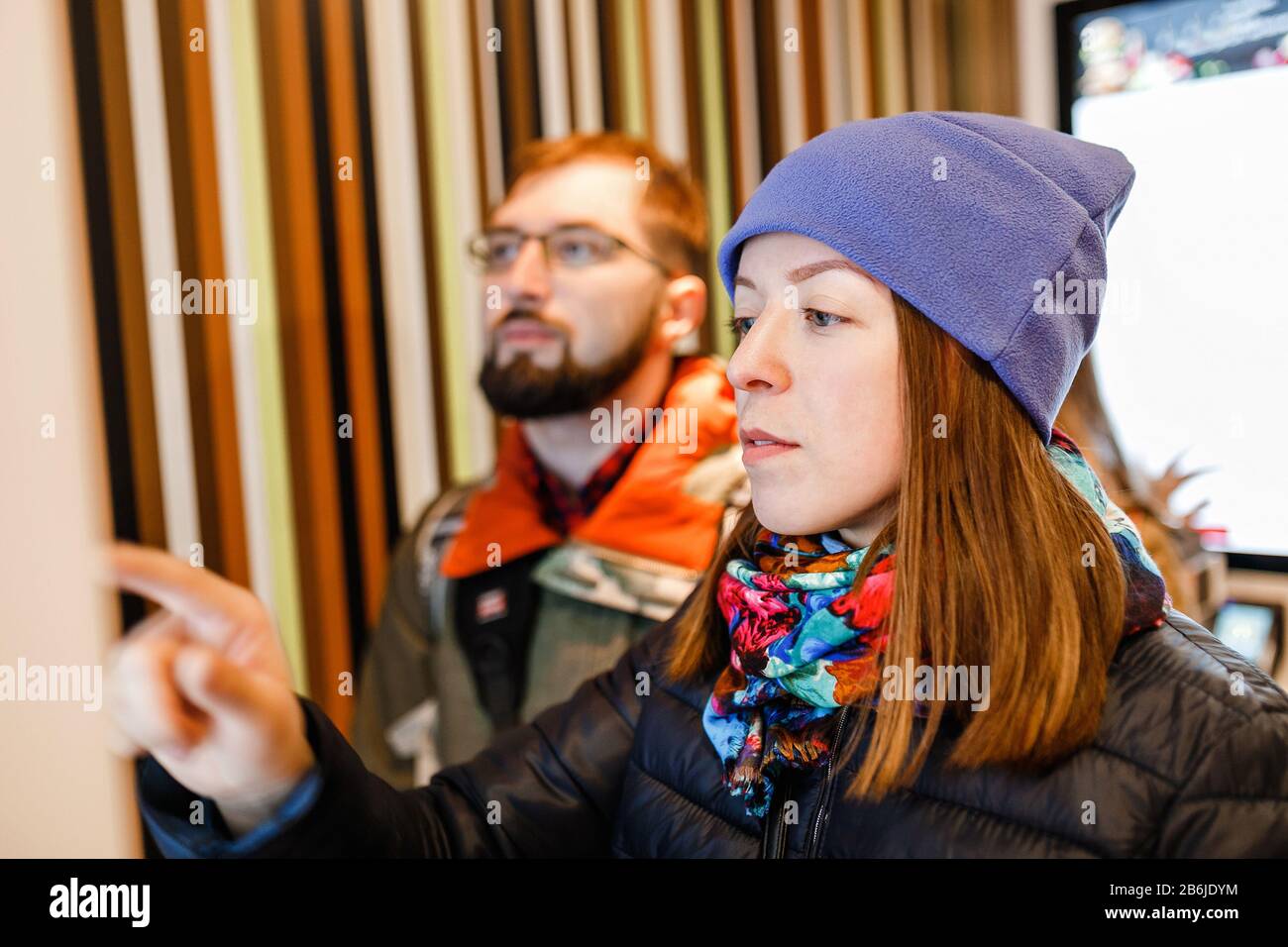 A woman orders food in the touch screen terminal in the electronic menu ...