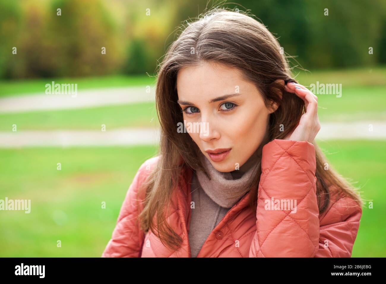 Close Up Portrait Of A Young Beautiful Brunette Model In Coral Coat
