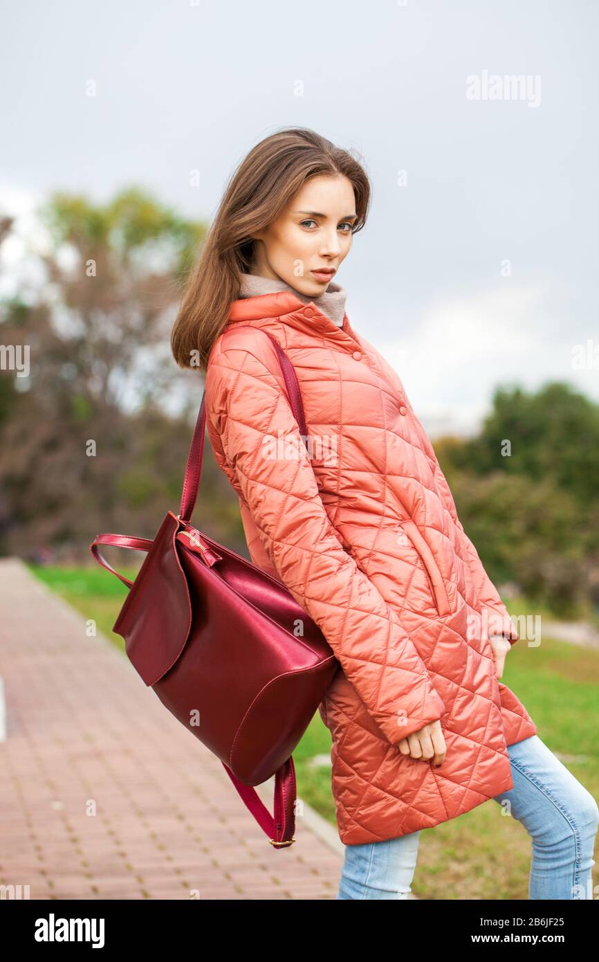 Close up portrait of a young beautiful brunette model in coral coat ...