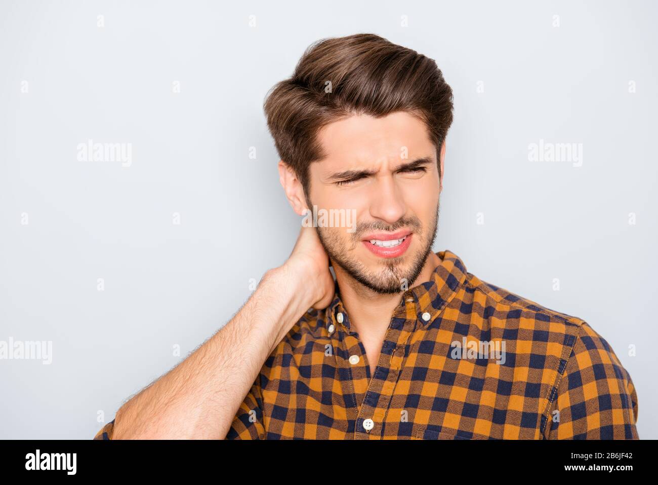 Young sick man having strong pain in neck Stock Photo - Alamy