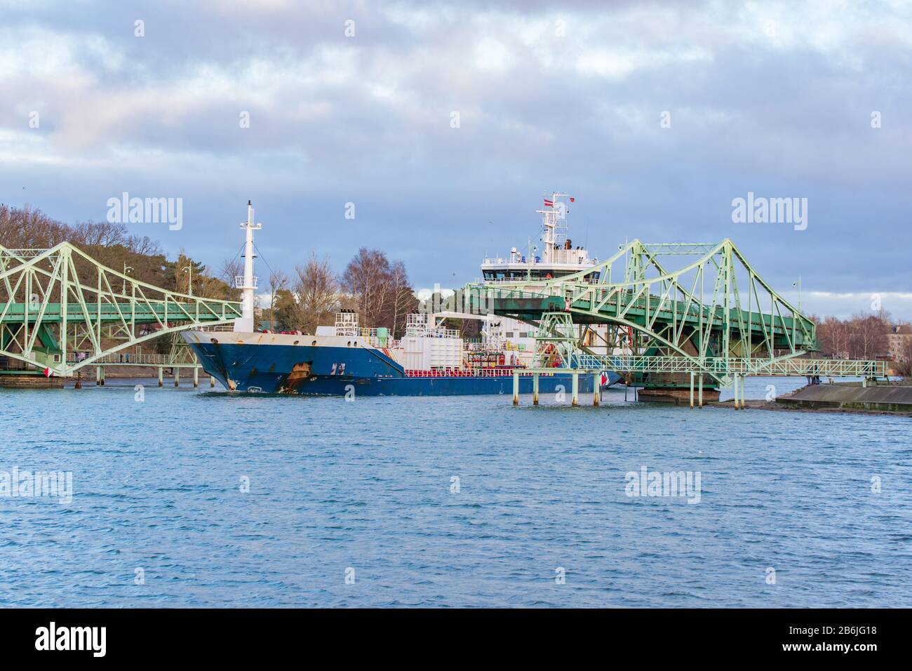 Opened green swing bridge with two rotating parts. Ship coming through ...