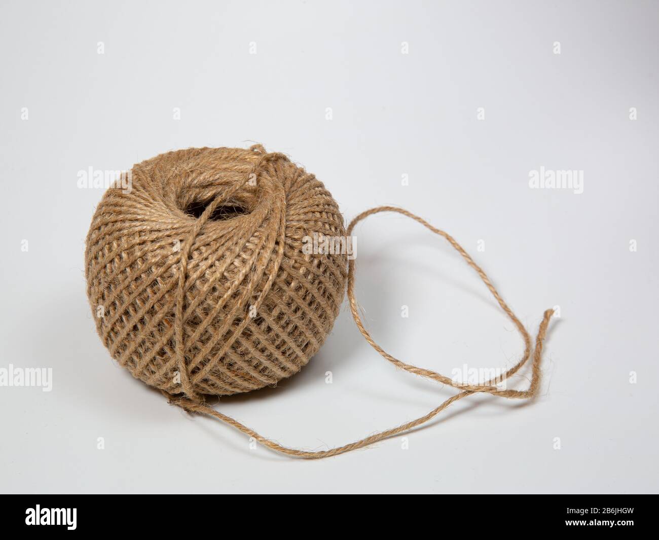 a partly uncoiled ball of string isolated on white background Stock ...
