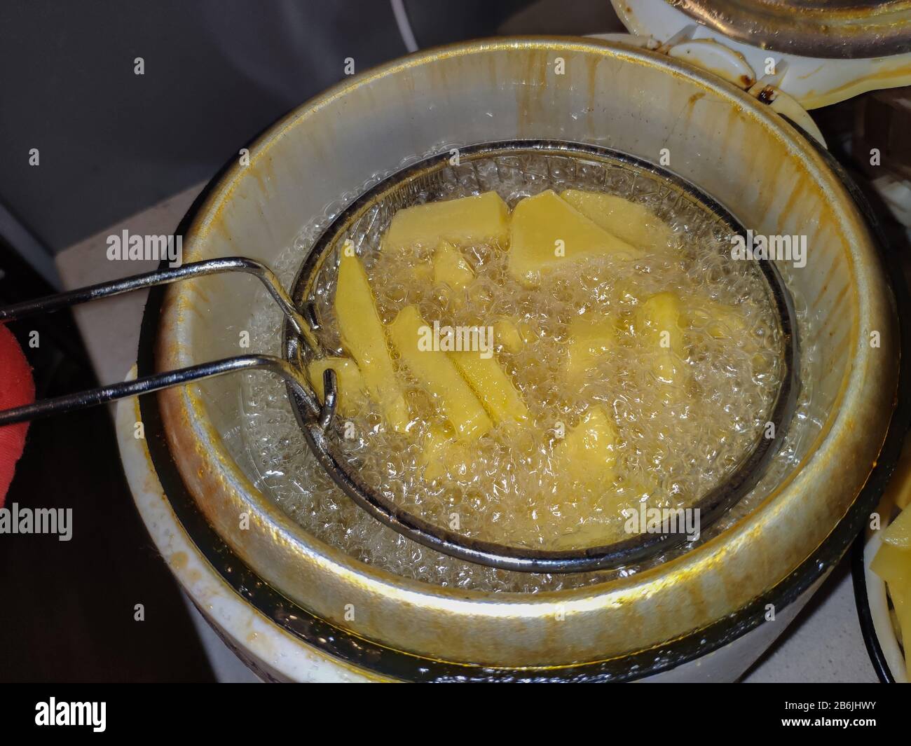Cooking home made french fries in dirty deep fryer Stock Photo - Alamy
