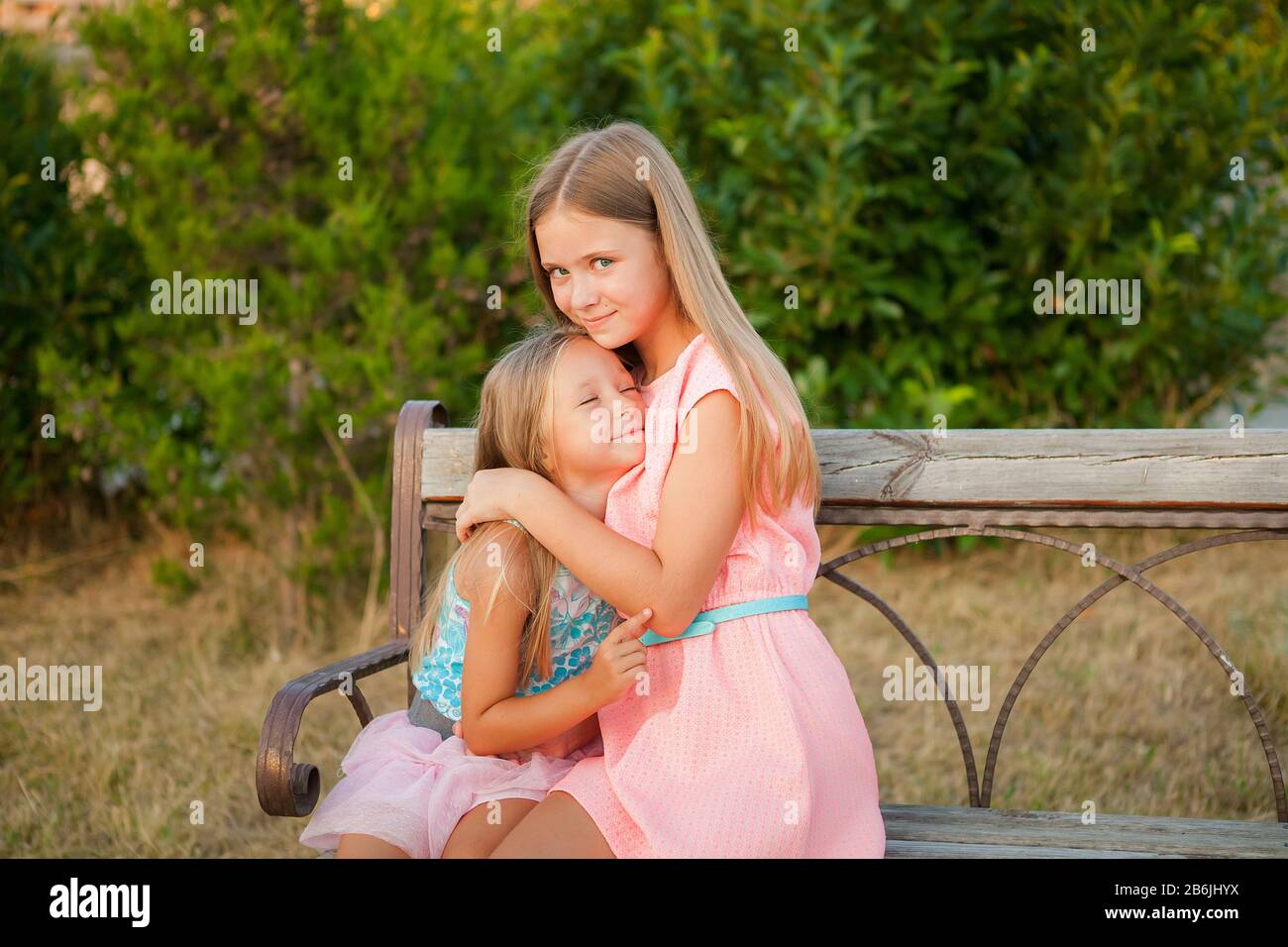 Two little girls sisters hugging in park. Cute kids girls play outdoors ...