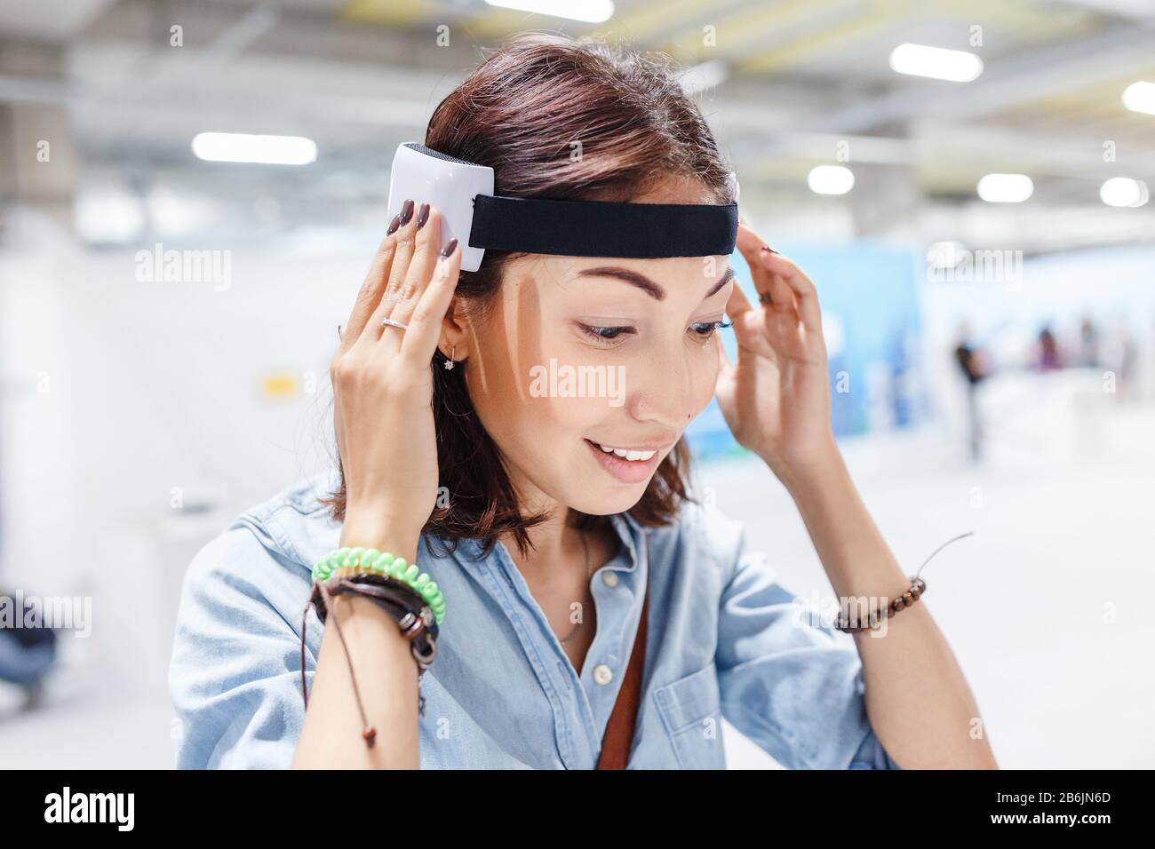 Woman with digital headset sensor connected to her ear, reading brain ...