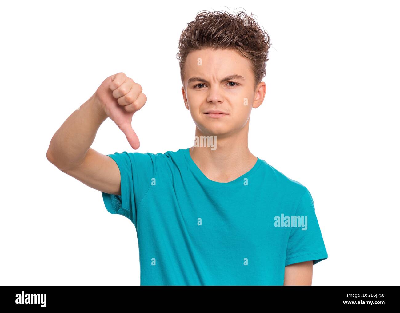 Portrait of teen boy giving thumb down gesture looking with negative ...