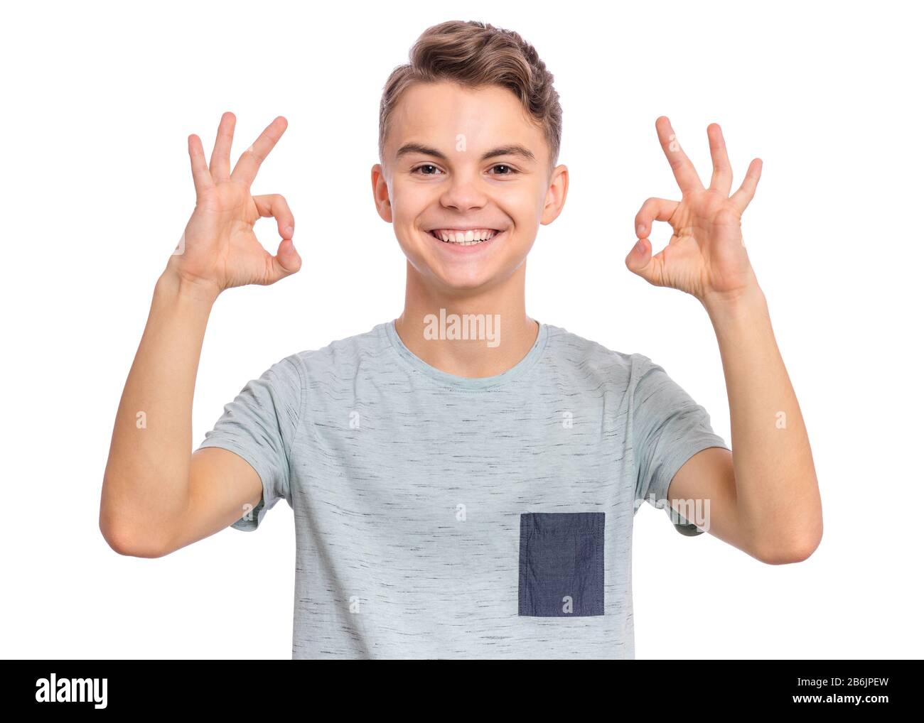 Portrait of teen boy making Ok gesture, isolated on white background ...