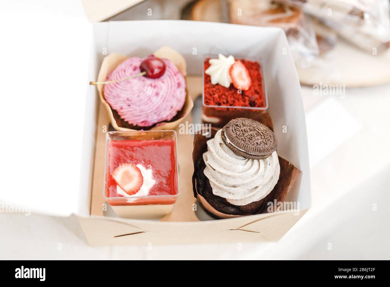 Selling cupcakes and muffins at the showcase in candy shop Stock Photo ...