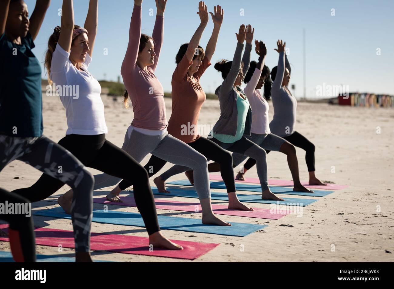 Side view of women doing yoga positions at the beach Stock Photo - Alamy