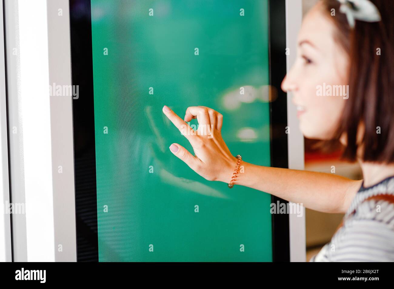 Group of people, friends ordering food at the touch screen self service ...