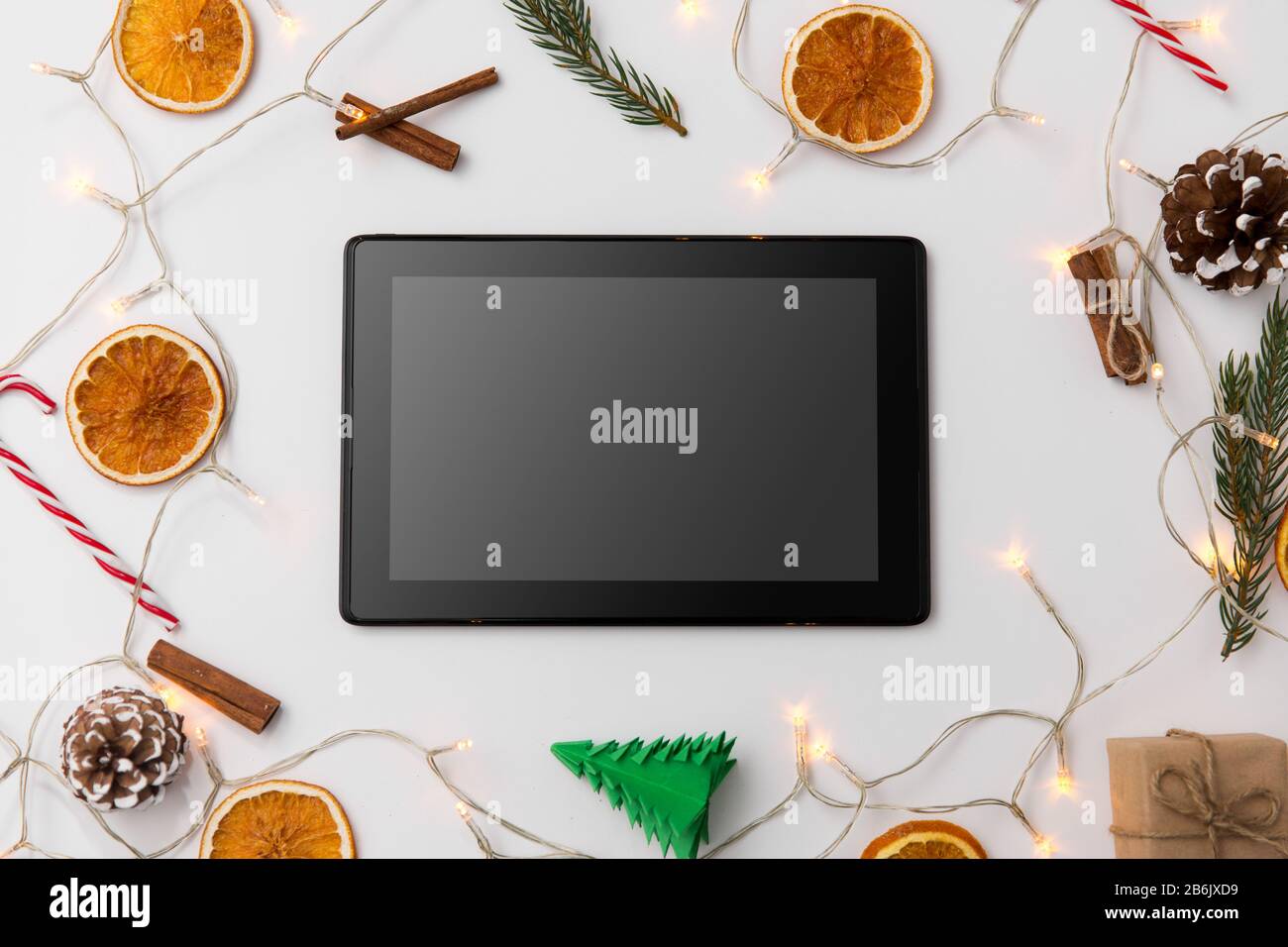 christmas, holidays and technology concept - tablet computer, garland ...