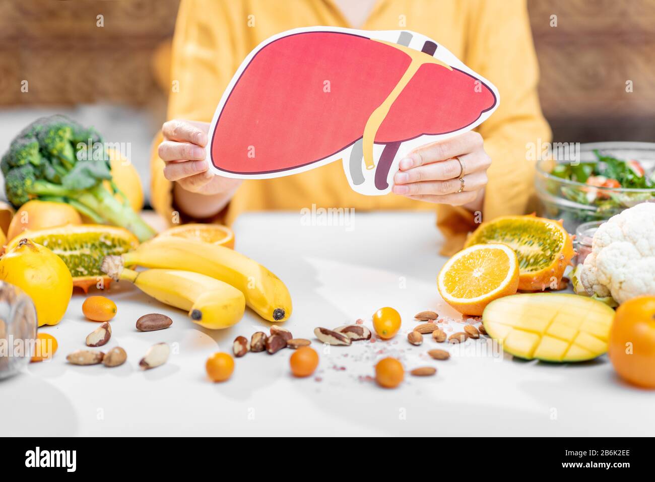 Holding human liver model with variety of healthy fresh food on the ...