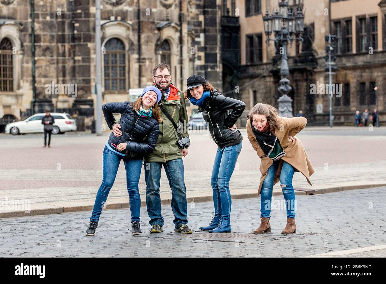 Group of young people standing in funny poses, travel and humor ...