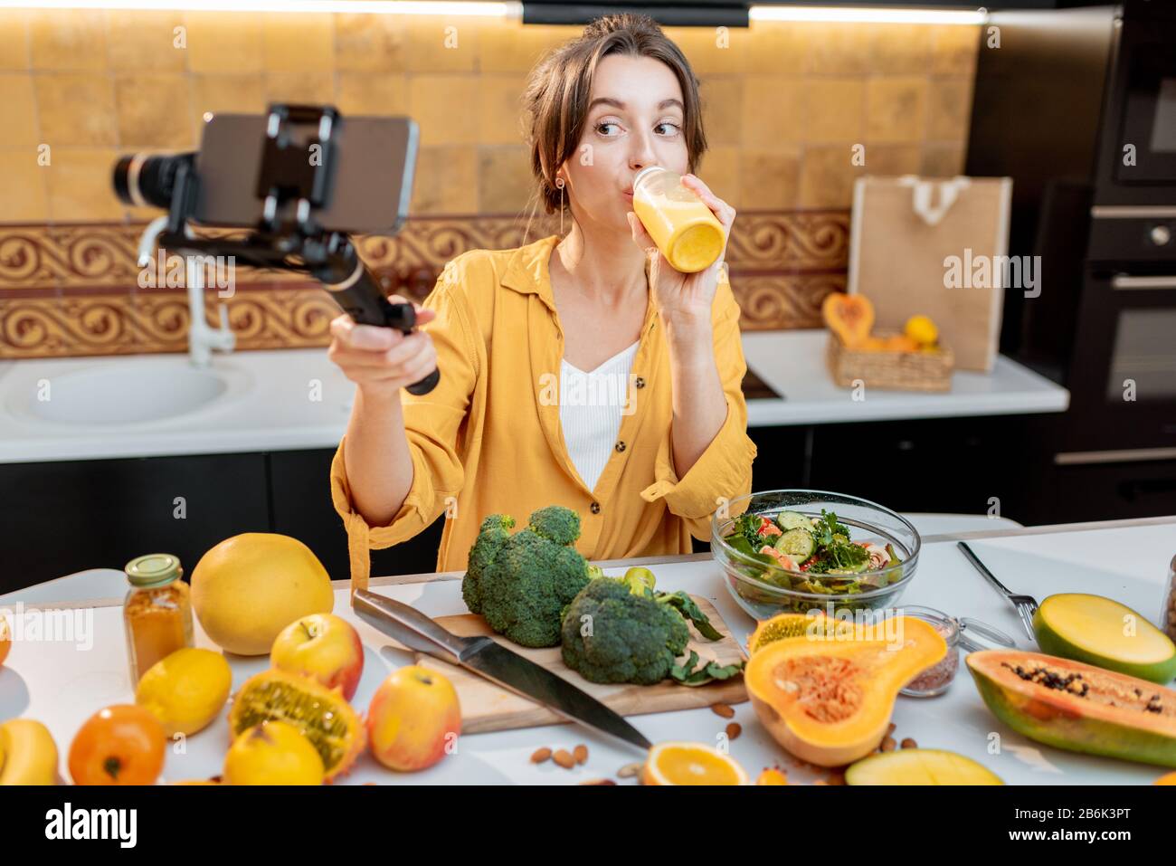Young and cheerful woman vlogging on mobile phone about healthy food ...