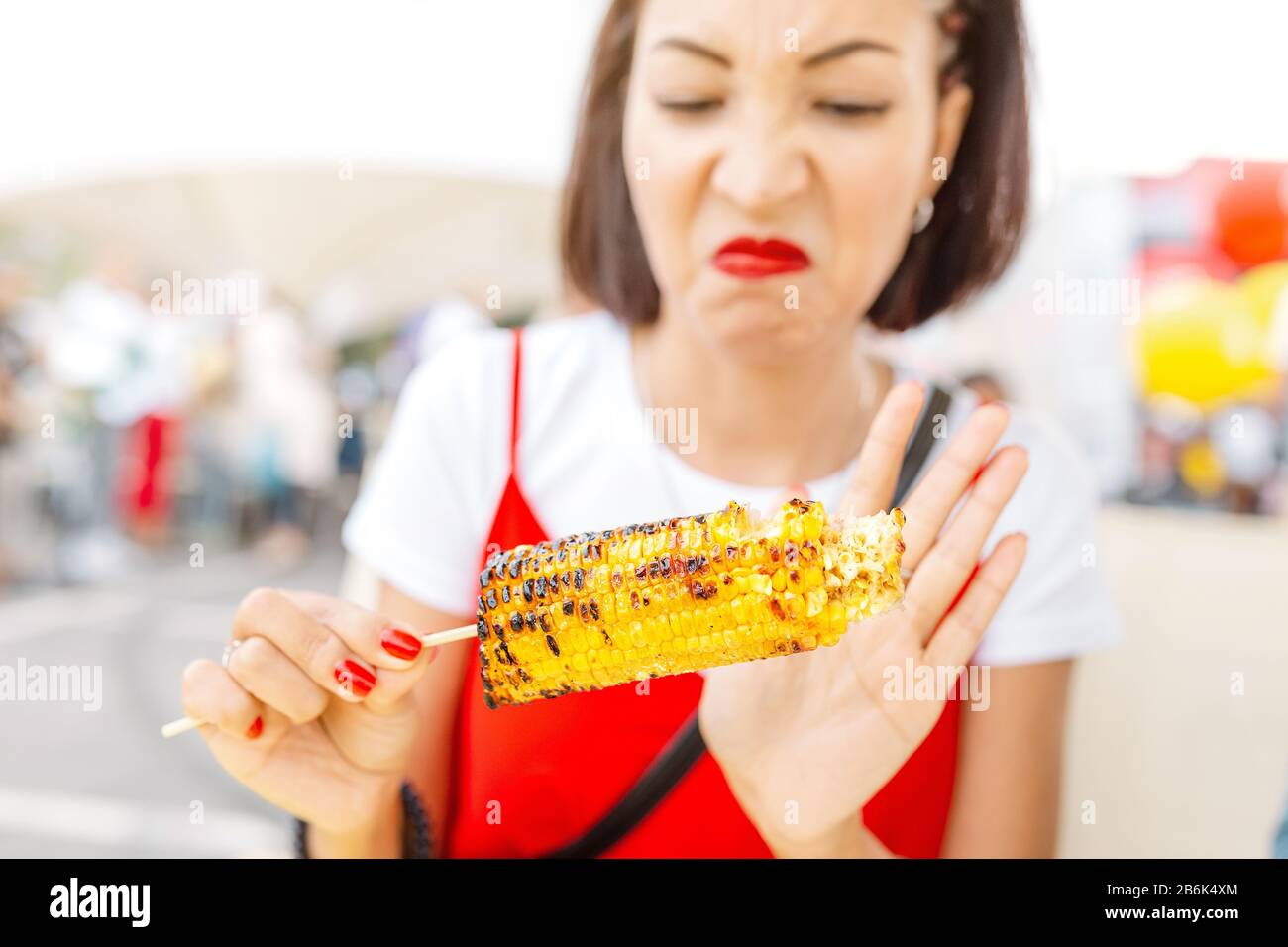 A woman refuses to eat sweet corn. The concept of spoiled food and junk ...