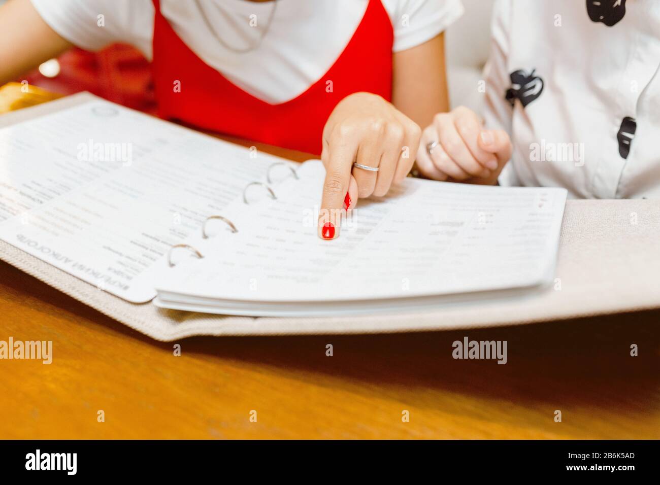two happy girl friends choosing meal in menu in restaurant Stock Photo ...