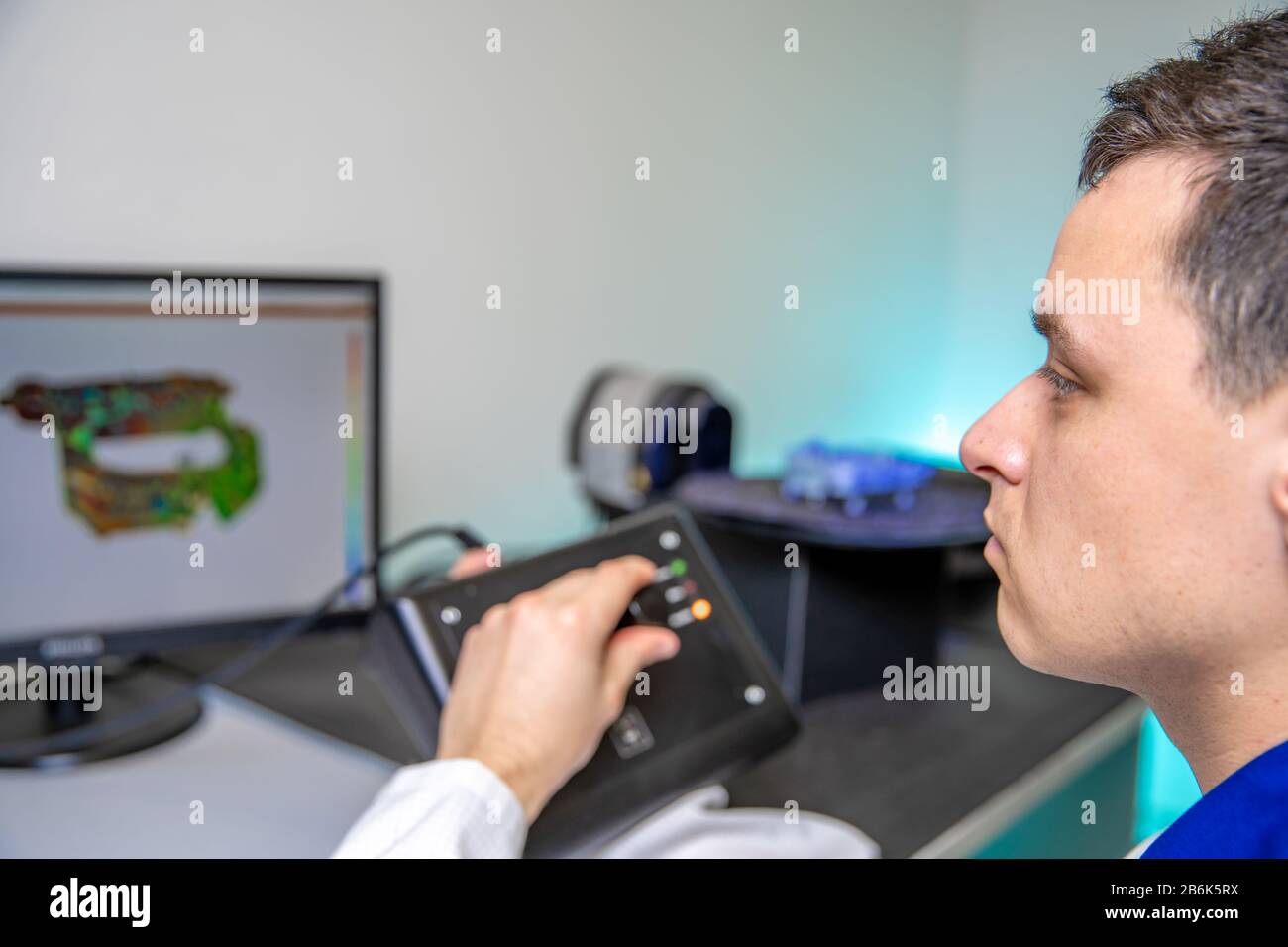 engineer scans high-quality plastic component with 3D scanner, rotating ...