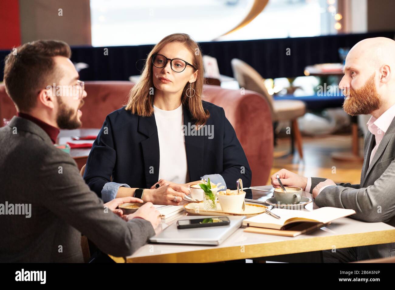Group of business executives sitting at table in restaurant and ...