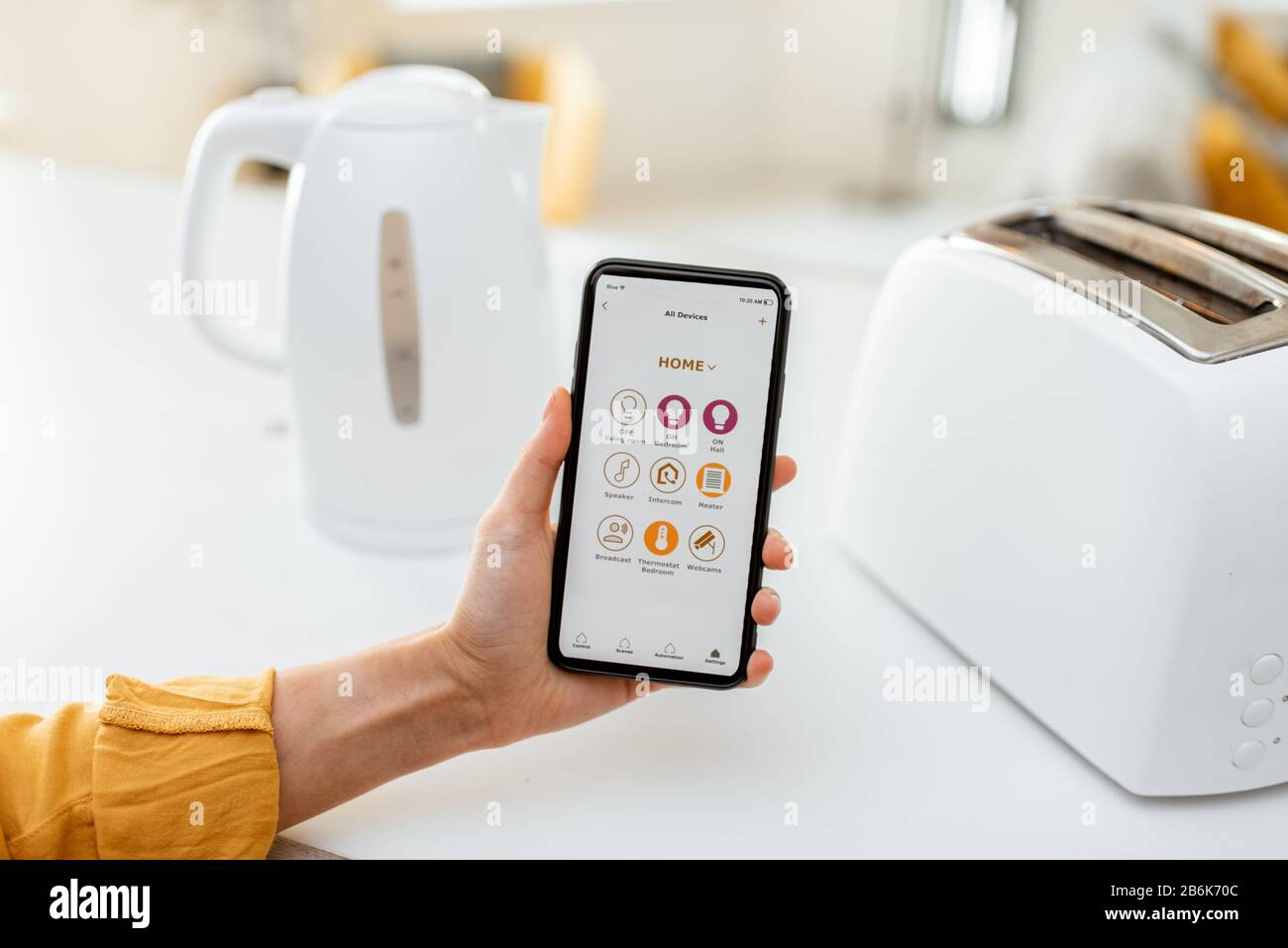 Controlling smart kitchen appliance using mobile phone at home, close ...