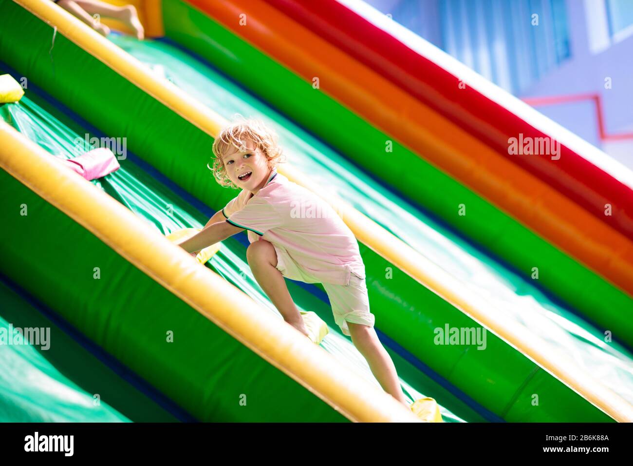 Child jumping on colorful playground trampoline. Kids jump in ...