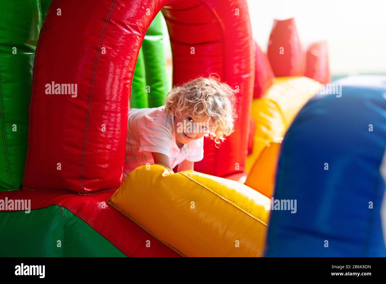 Child jumping on colorful playground trampoline. Kids jump in ...
