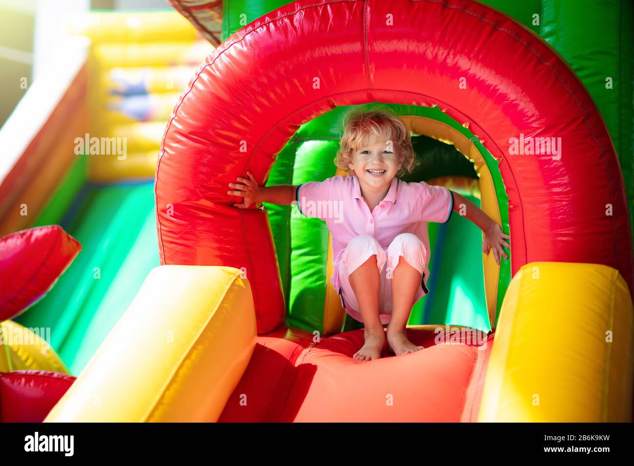 Child jumping on colorful playground trampoline. Kids jump in ...