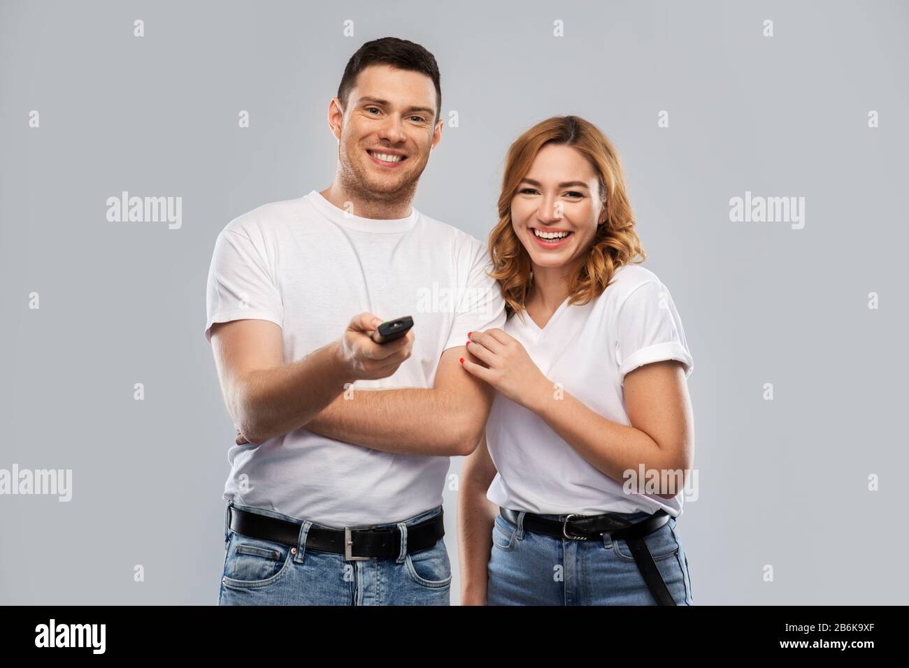 happy couple with tv remote control Stock Photo - Alamy