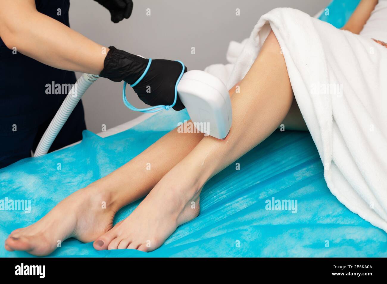 Young girl is getting laser hair removal for legs at beauty salon Stock ...