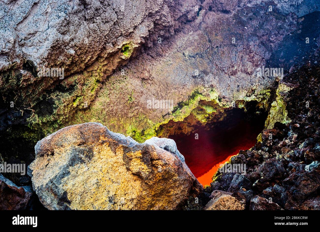 Looking into an active basalt lava flow from the solidified carapace, with red, incandescent ...