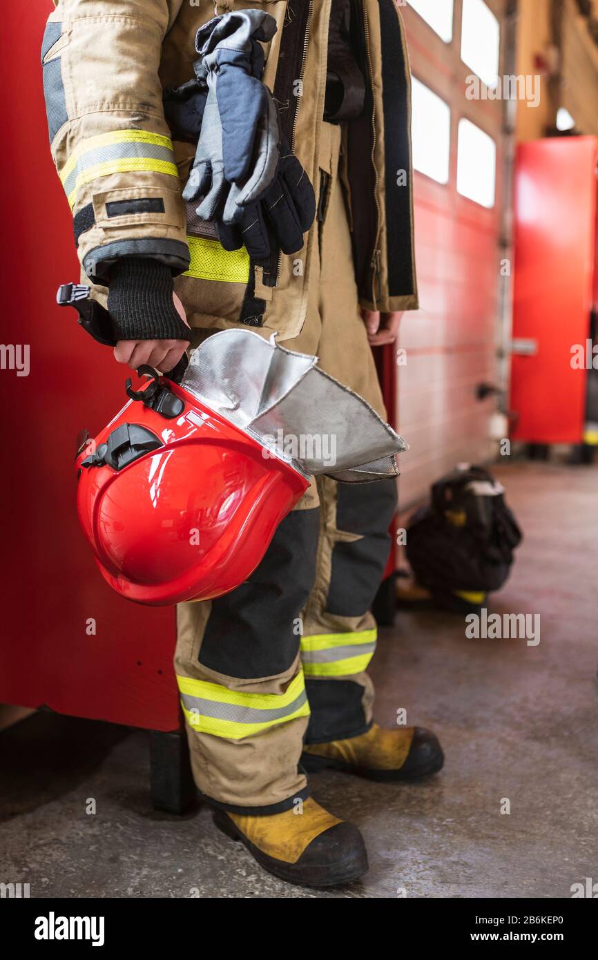 Red helmet in fireman's hand Stock Photo - Alamy