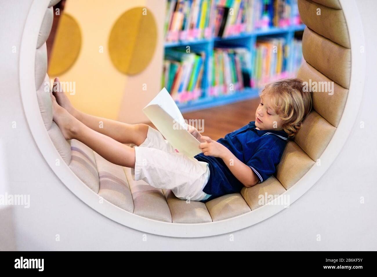 Child in school library. Kids read books. Little boy reading and ...