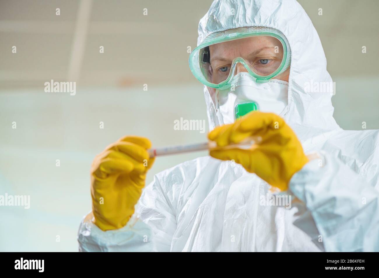 Female epidemiologist using medical sample test tube in virus ...
